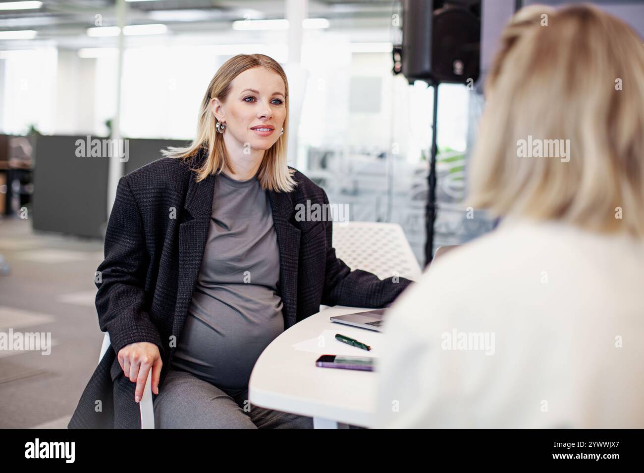 Pregnant female executive conducting an interview with an employee in ...