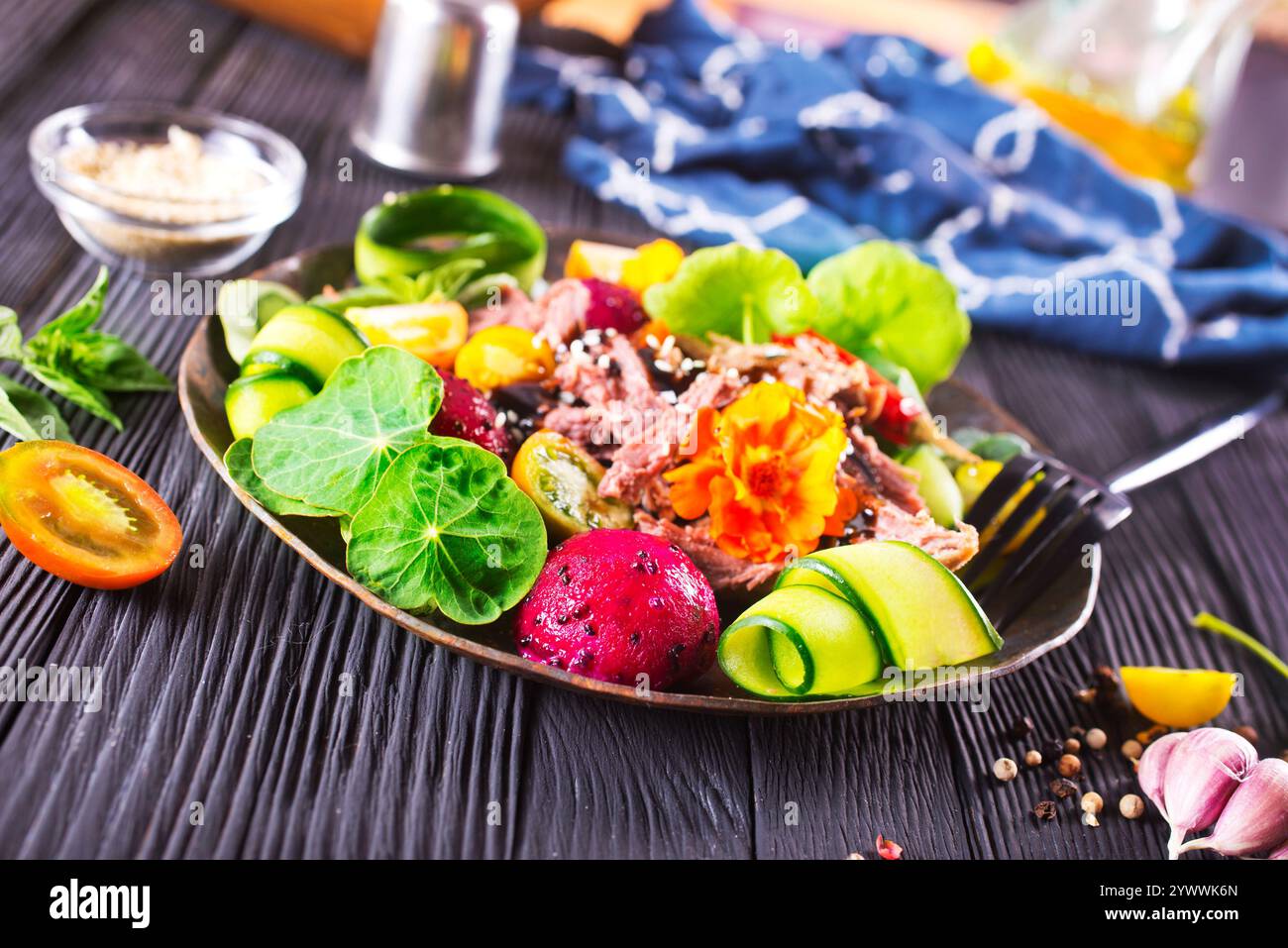 Meat steak decorated with nasturtium flowers. Sliced roasted pork steak ...