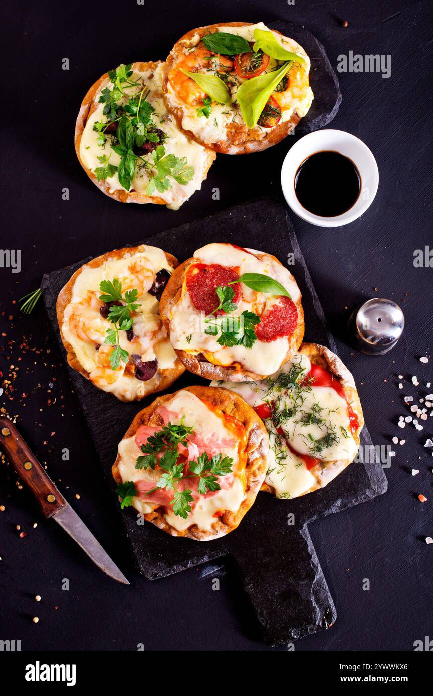 Mini pizzas - pizzette - topped with cheese and tomato plus Italian ham ...