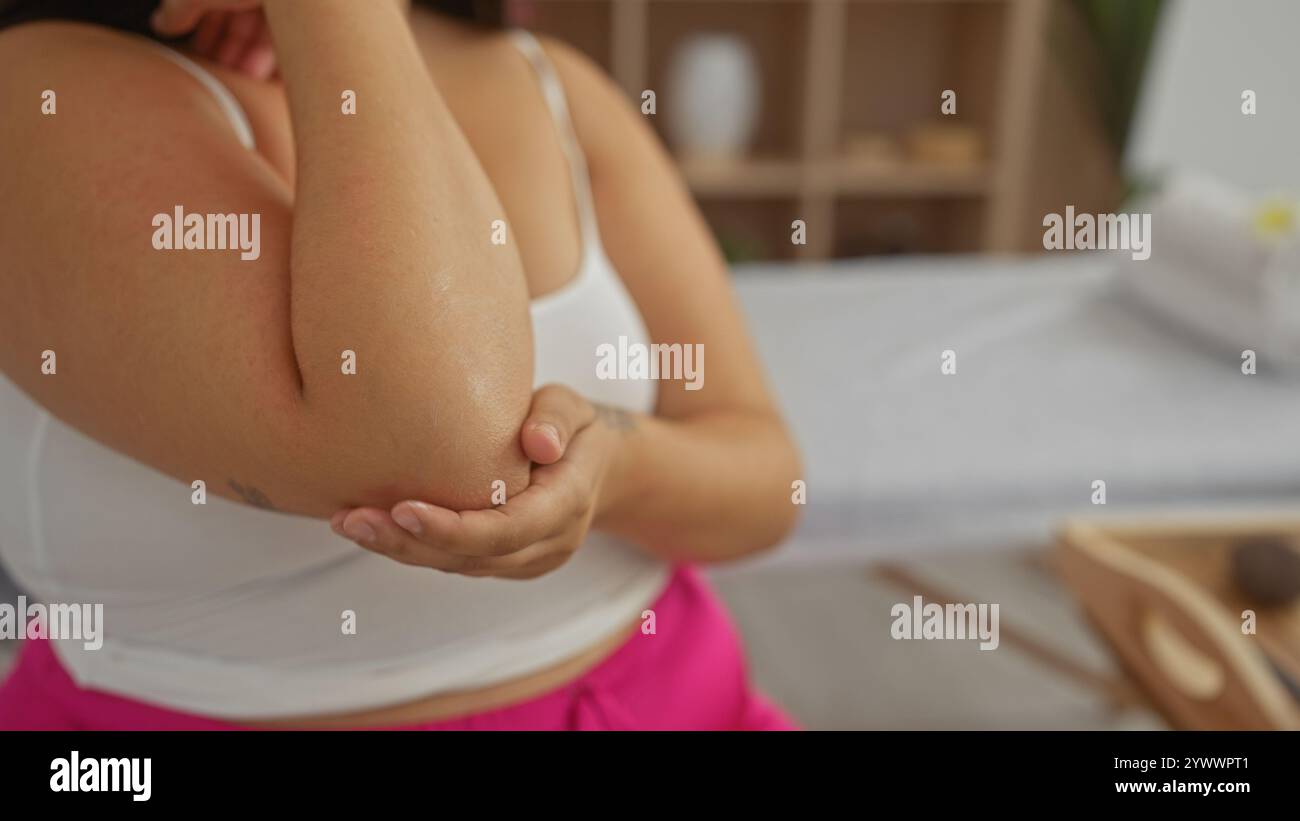 Woman moisturizing elbow in spa room with bright decor and a cozy ...