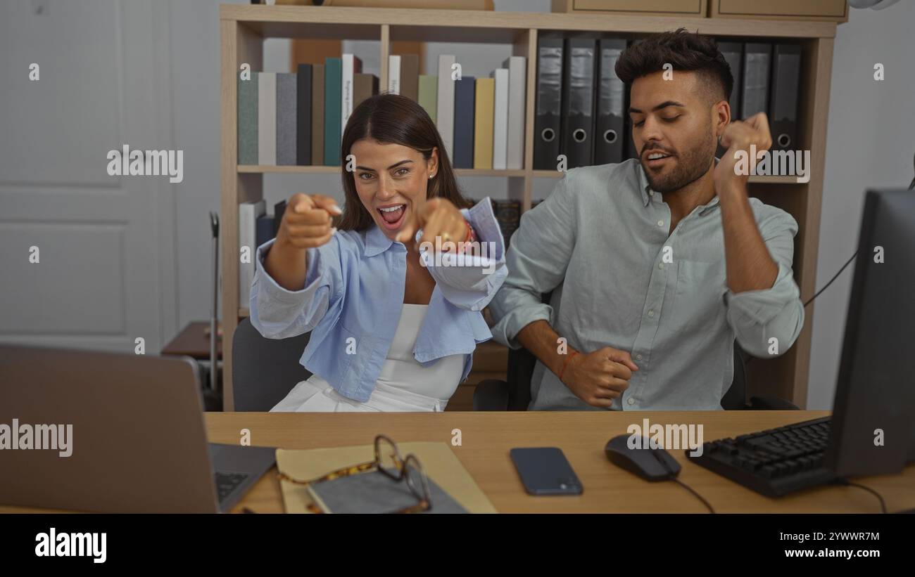 Woman and man enjoying a playful moment in the office, surrounded by ...