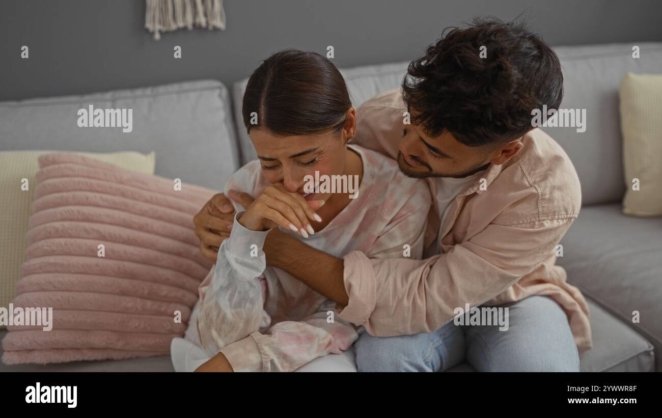 Man comforting crying woman on a couch in home while sitting indoors ...