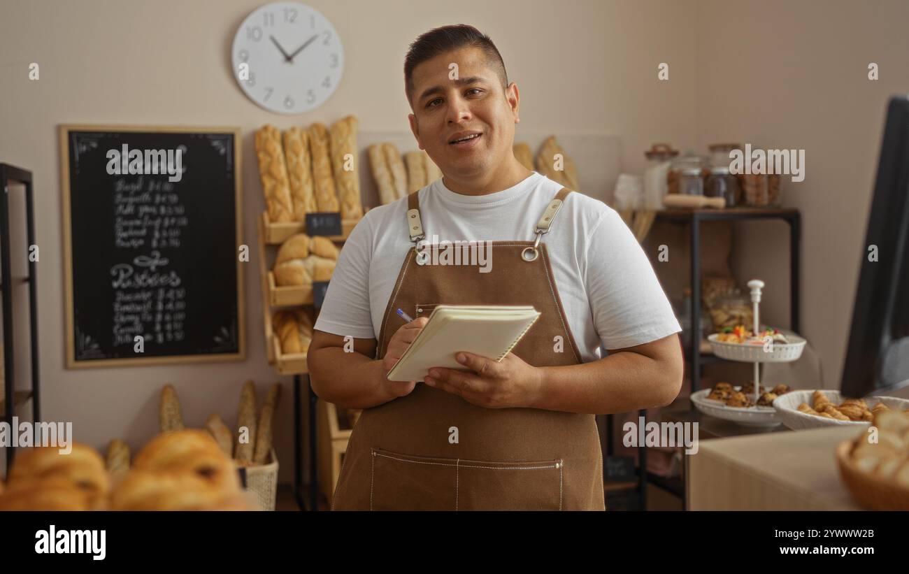 Hispanic man taking notes in a bakery with bread and pastries displayed ...
