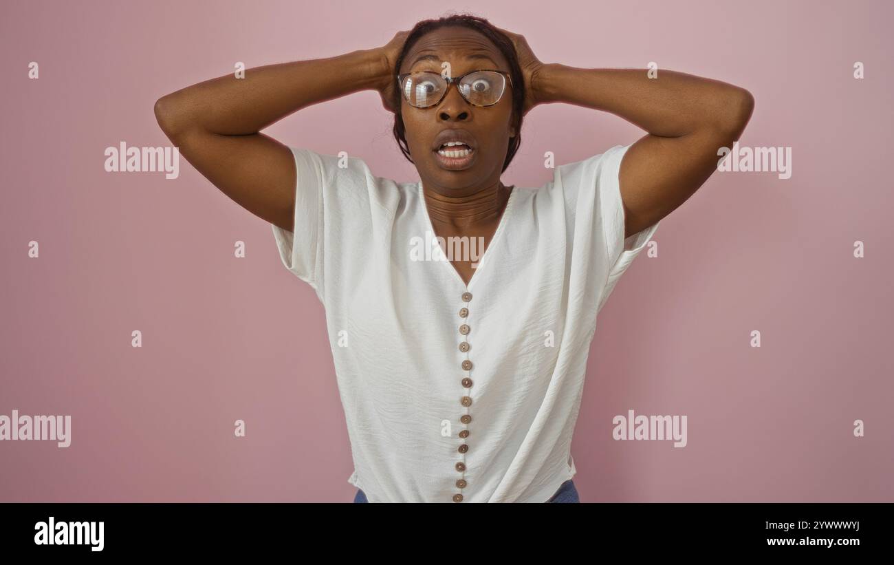 Woman holding her head in surprise over isolated pink background ...