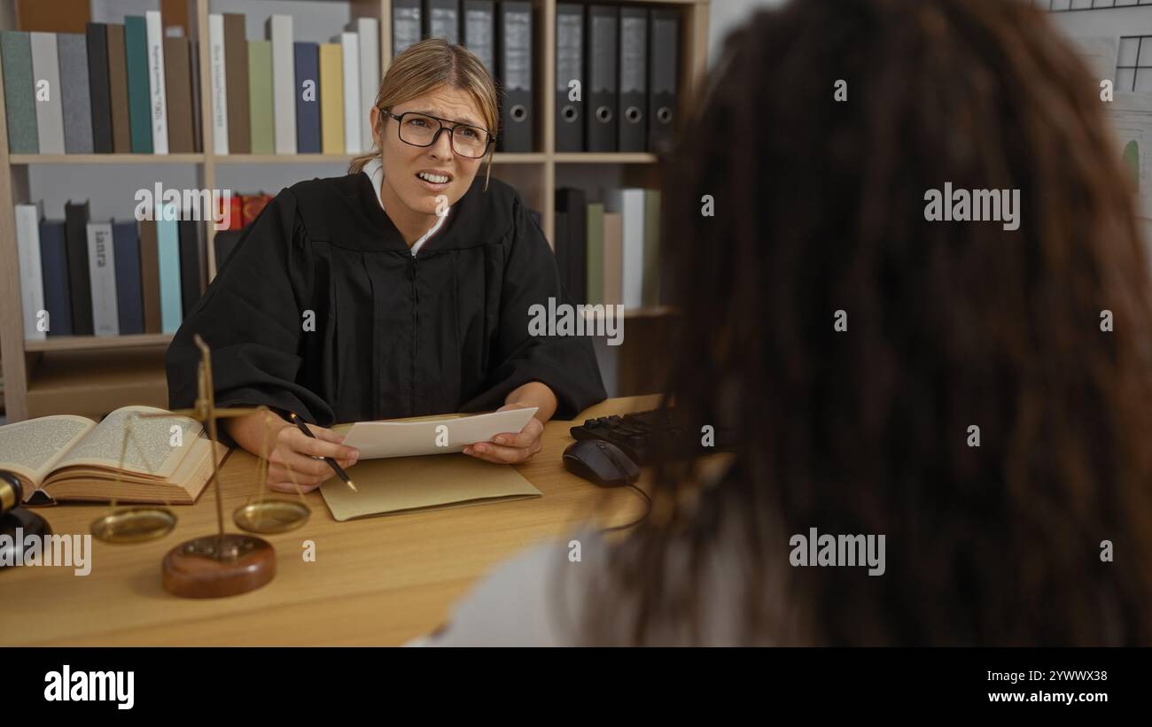 Woman judge talking to client indoors in courthouse office with legal ...