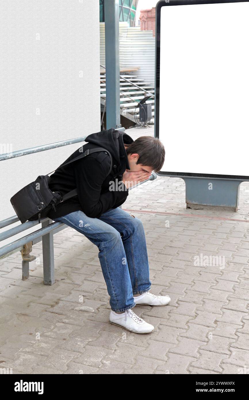 Sad Young Man Sitting at the Bus Stop at the City Street Stock Photo ...