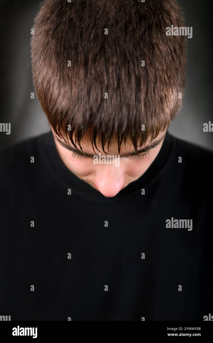Portrait of Teenager With Lowered Head on the Black Background Stock ...