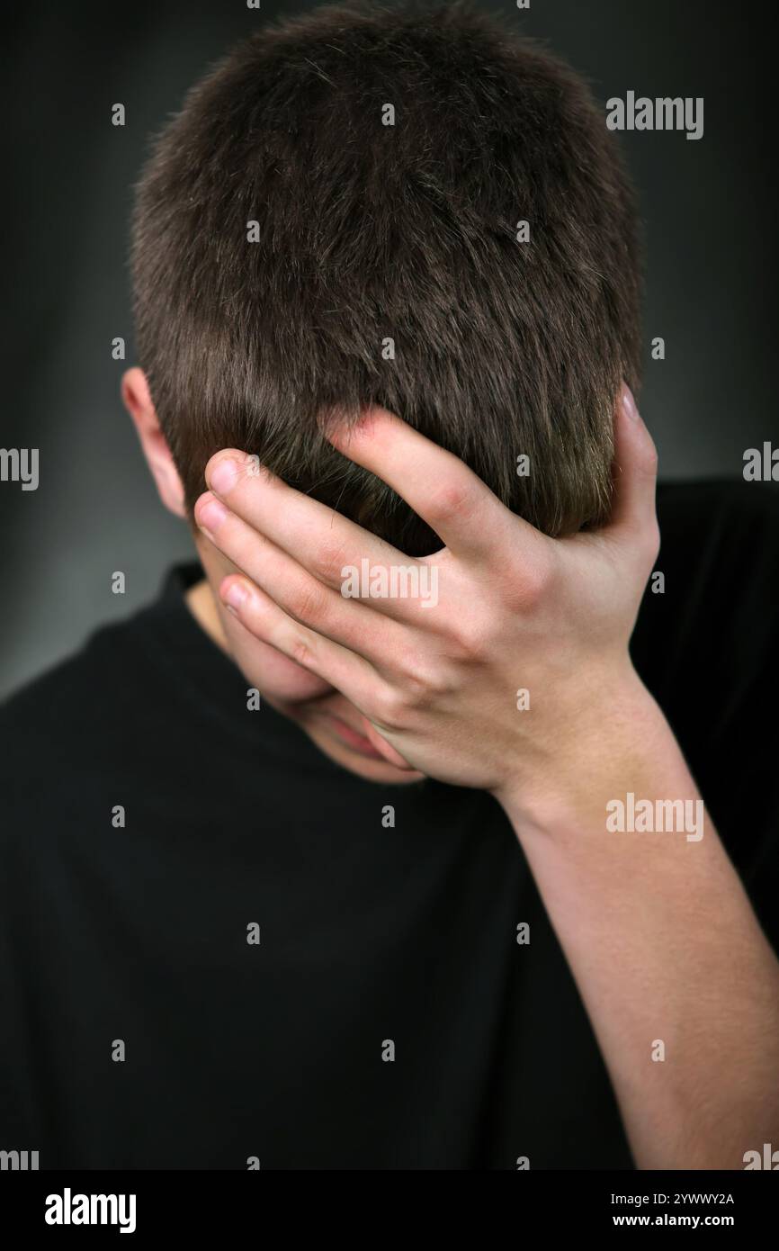 Sad Young Man On the Black Background hide his Face Stock Photo - Alamy
