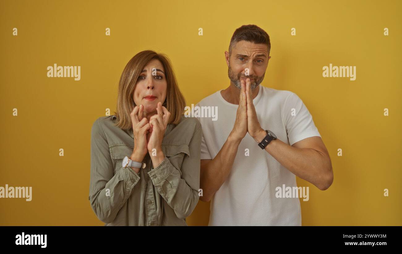 Woman with crossed fingers and man with hands together making a ...