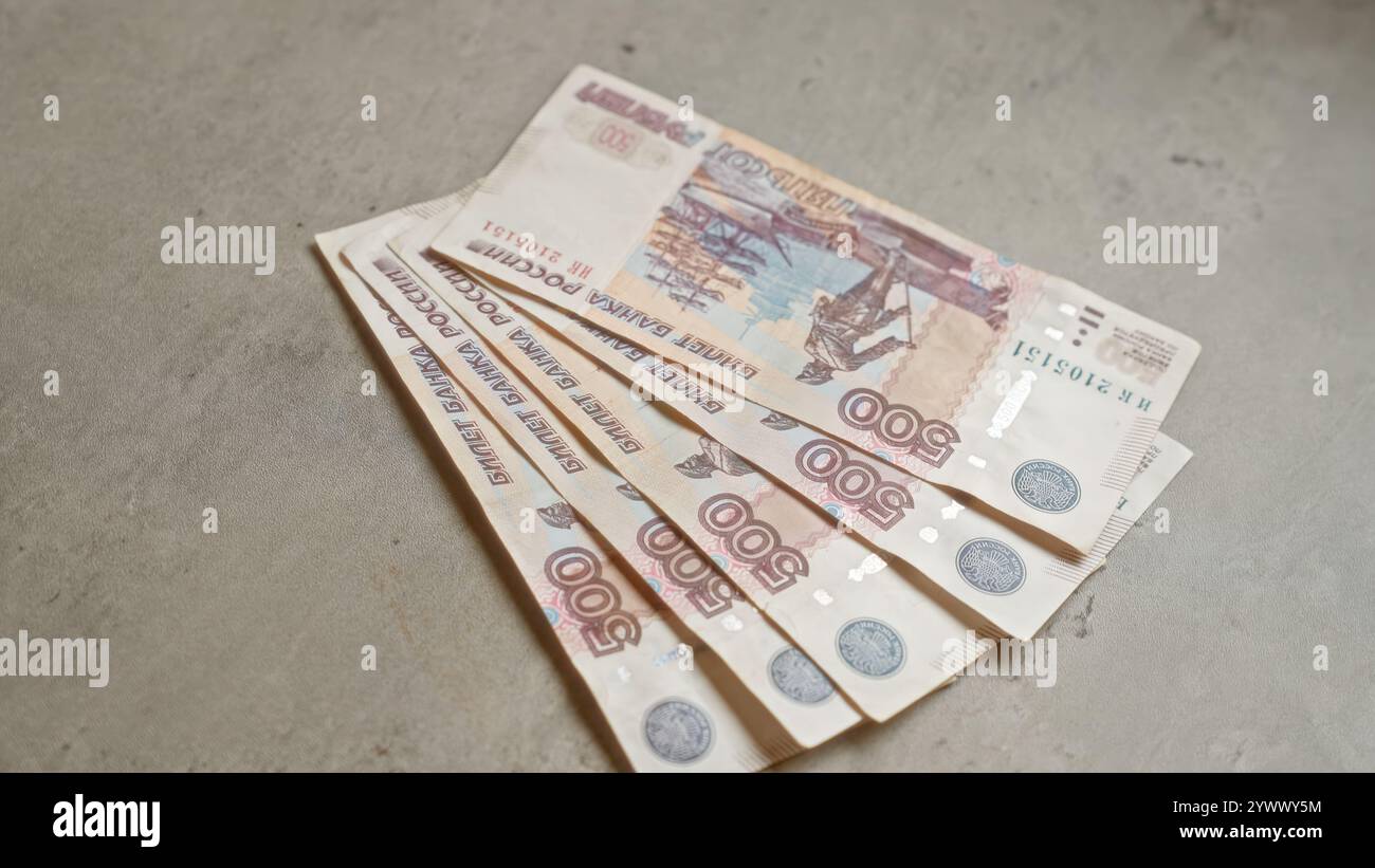 Russian ruble banknotes arranged on a concrete surface, showcasing the ...