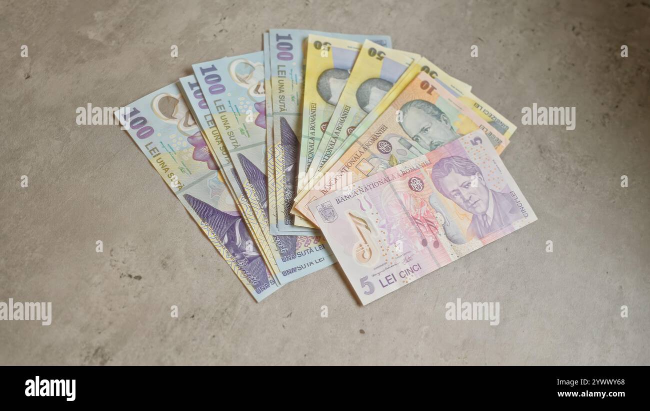 Romanian leu banknotes spread on a concrete surface, showcasing the ...