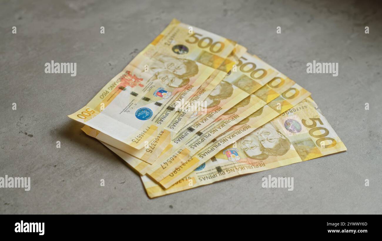 Five 500 philippine peso banknotes on a concrete surface symbolize ...