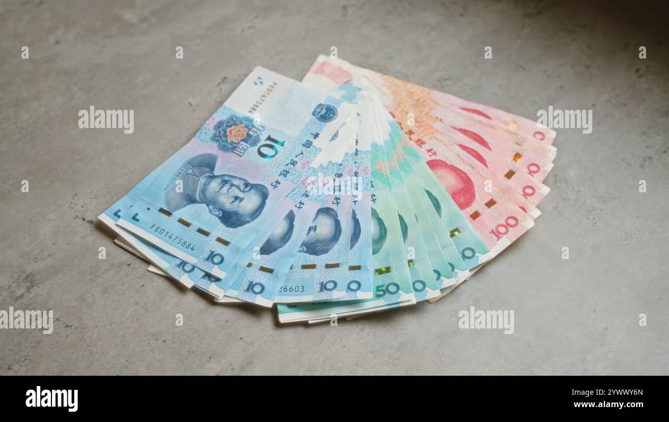 Chinese yuan banknotes spread over a concrete surface showcasing ...