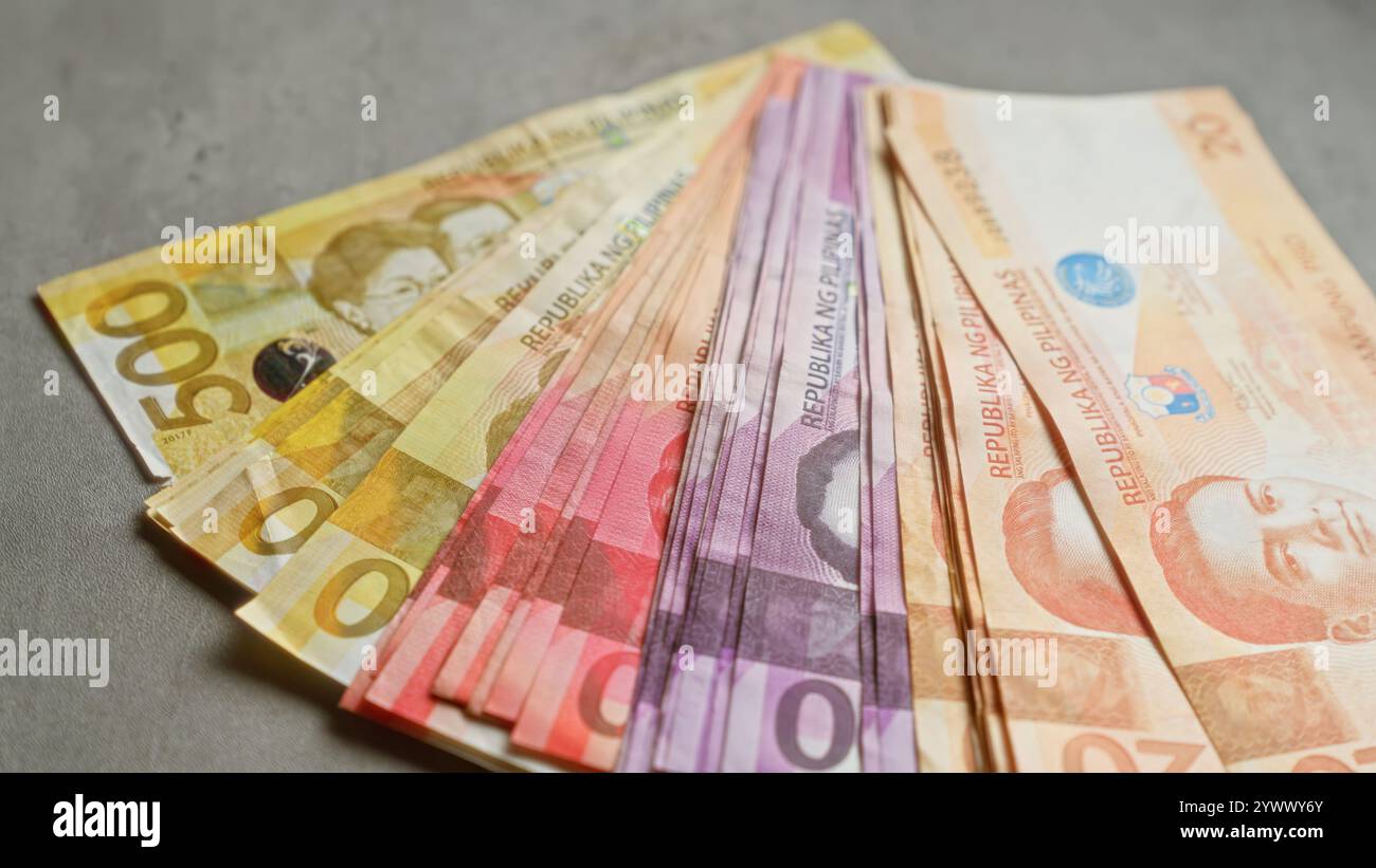 Philippine banknotes laid out on concrete surface, showcasing various ...