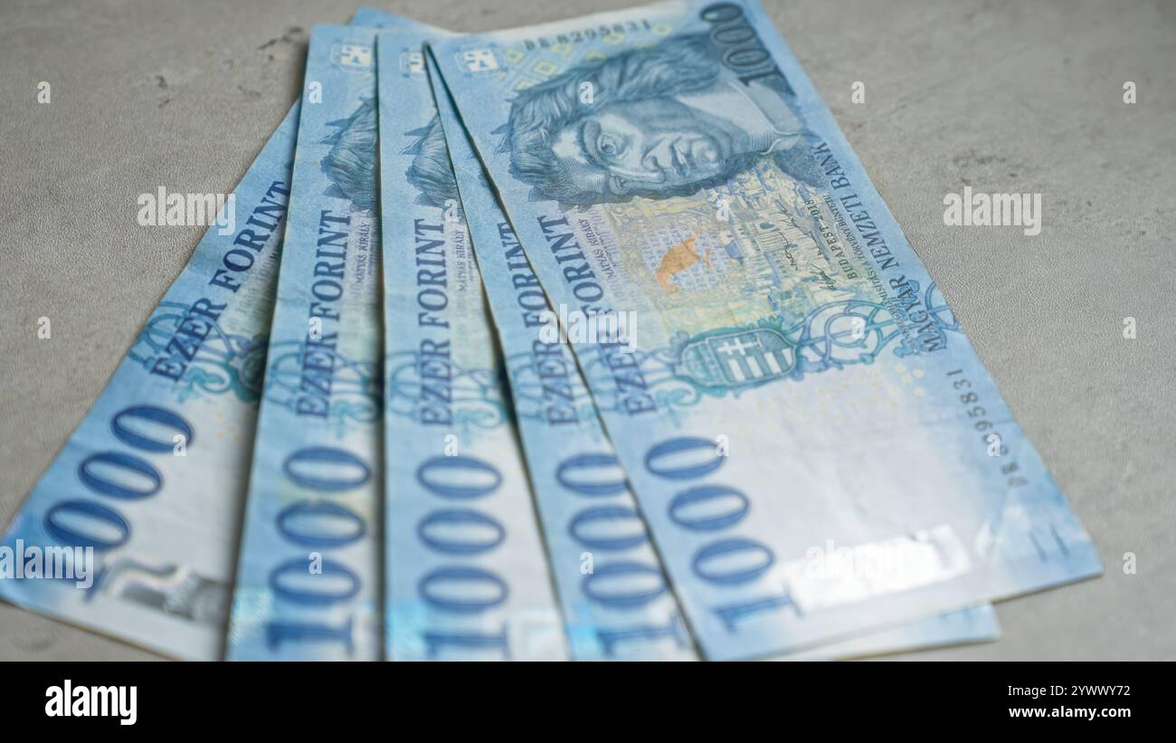 Hungarian forint banknotes spread out on a concrete surface ...