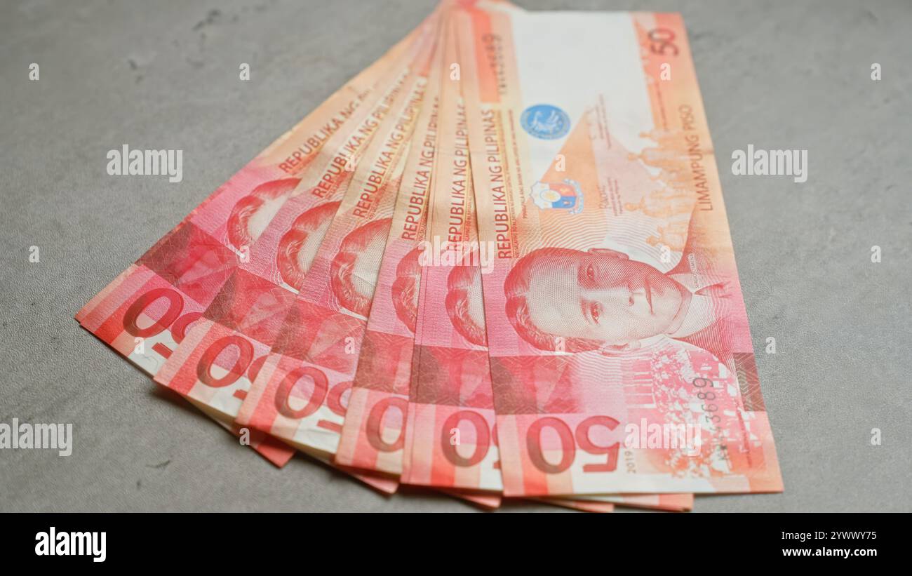 Philippine banknotes arranged on a concrete surface showcasing a stack ...