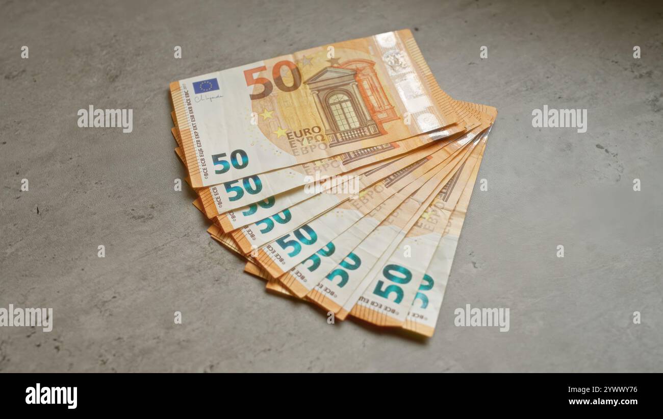 Euro banknotes from the european union displayed on a concrete surface ...