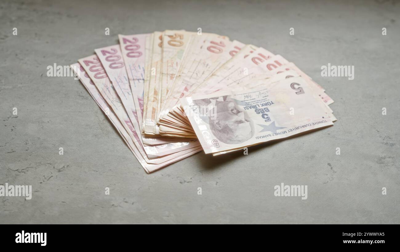 Turkish lira banknotes spread out on a concrete surface, showcasing ...
