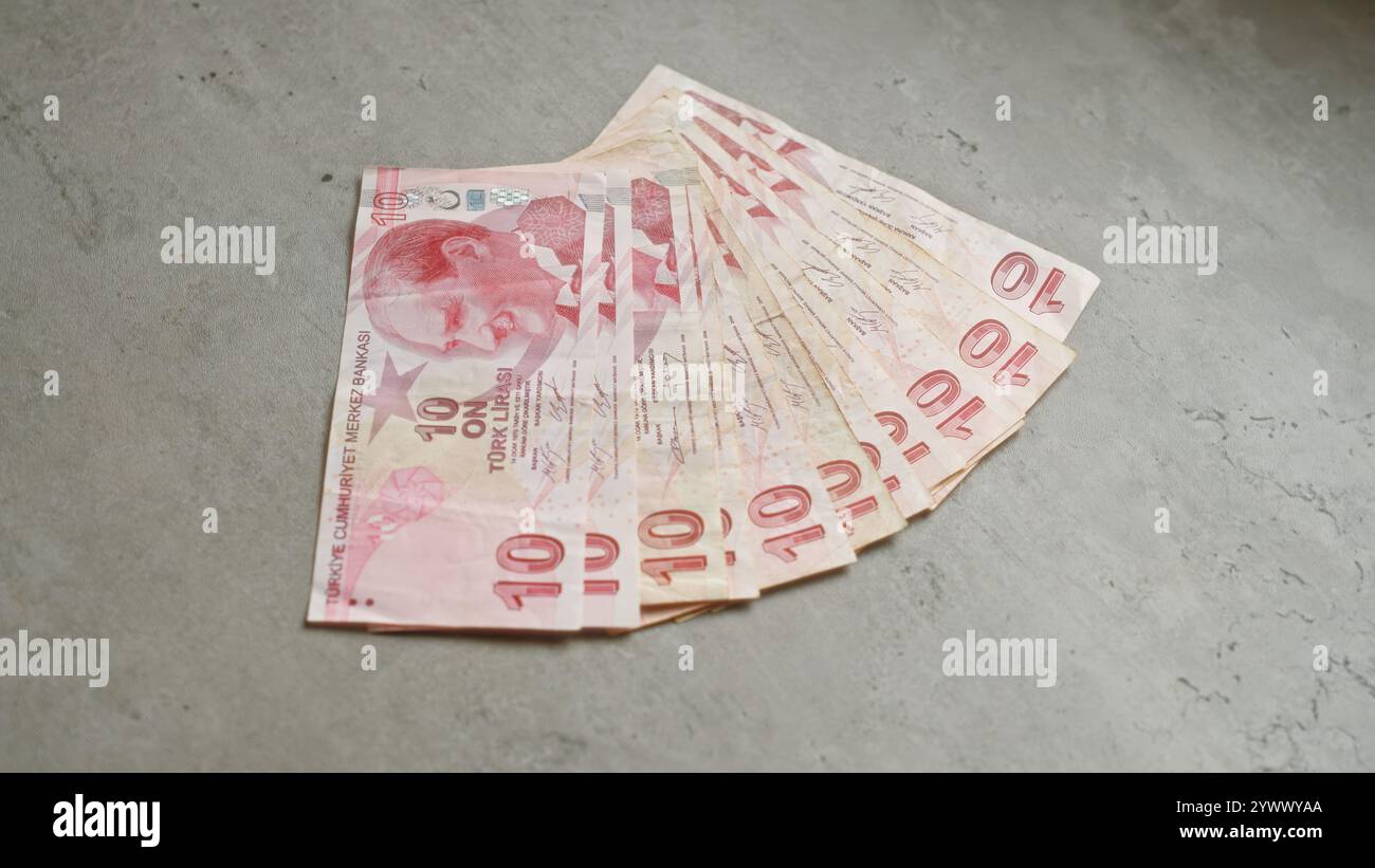 Turkish lira banknotes spread out on a concrete surface, showcasing 10 ...