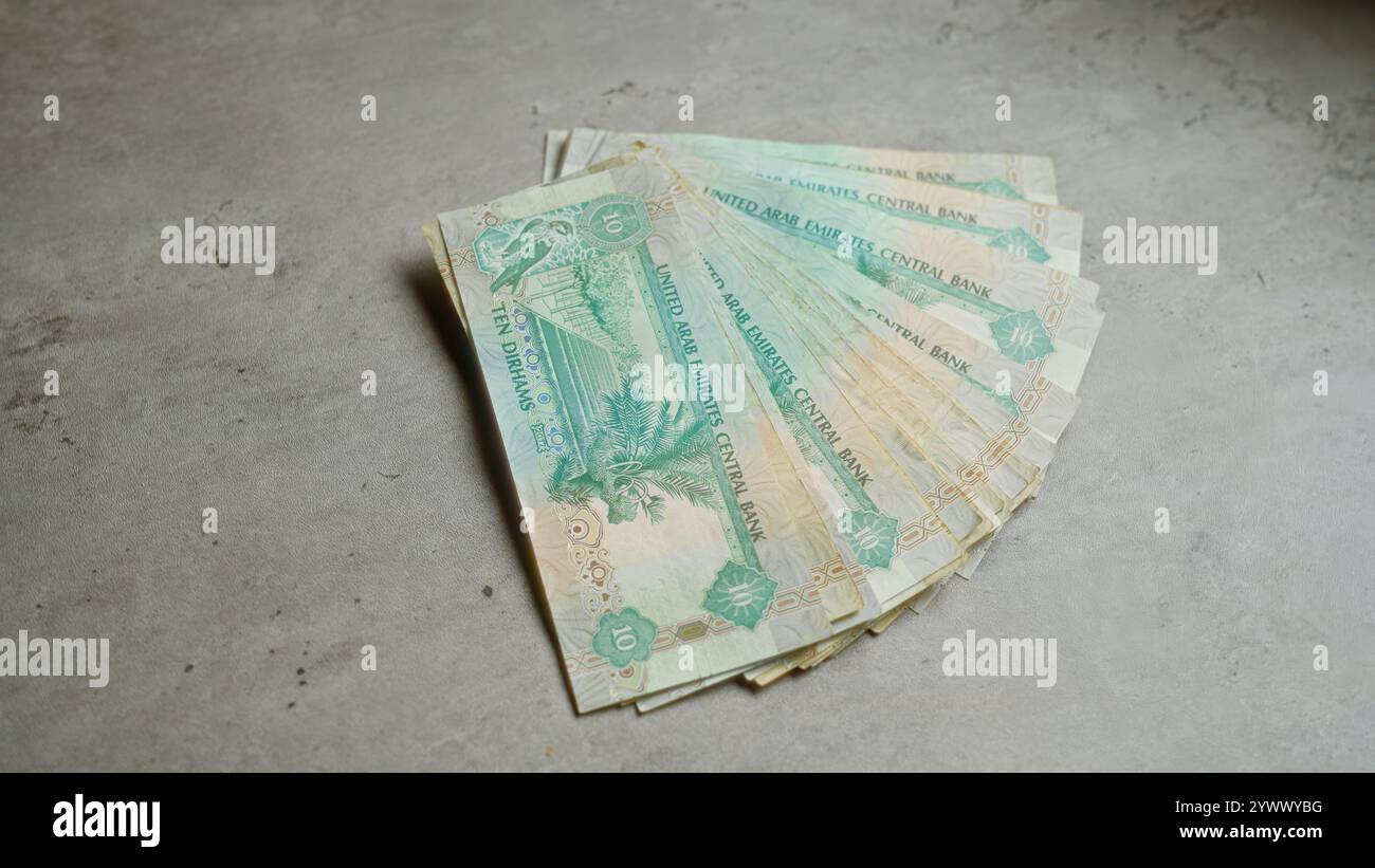 United arab emirates dirham banknotes spread out on a concrete surface ...