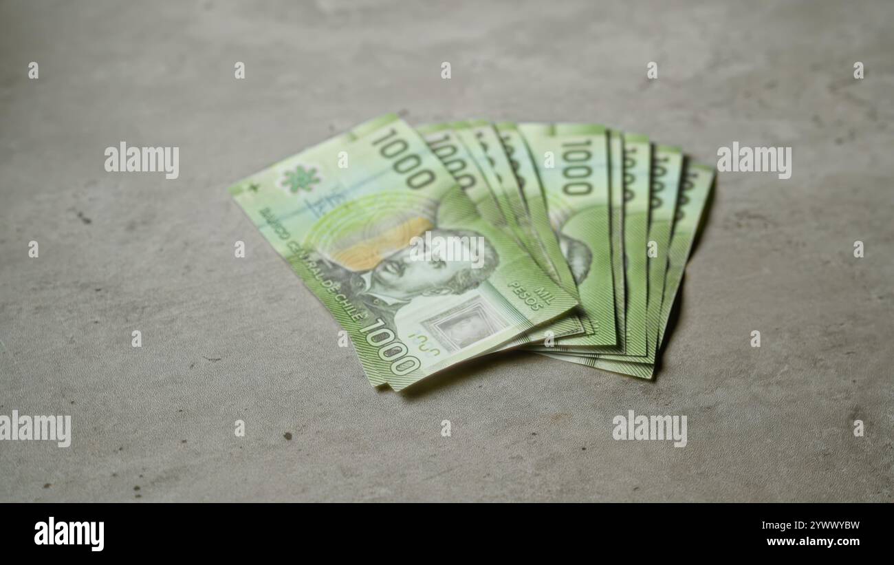 Chilean banknotes in denominations of 1000 pesos are spread out on a ...