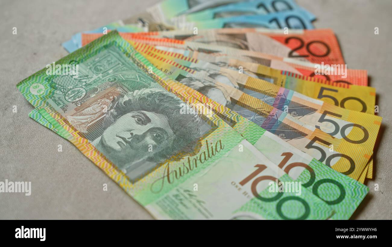 Australian banknotes in various denominations are spread out on a ...