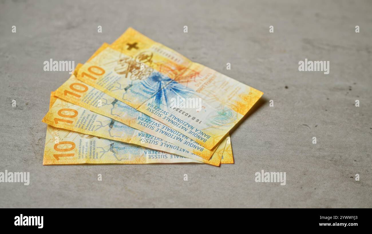 Swiss ten-franc banknotes displayed on a concrete surface showcasing ...
