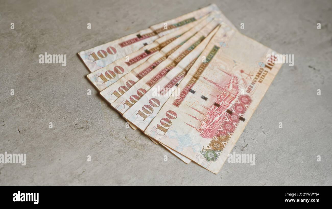 Saudi arabian 100 riyal banknotes spread in a fanned arrangement on a ...