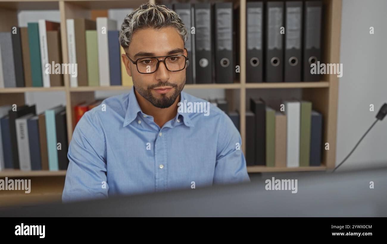 Arab man with beard and glasses working in office, surrounded by shelves with files Stock Photo ...