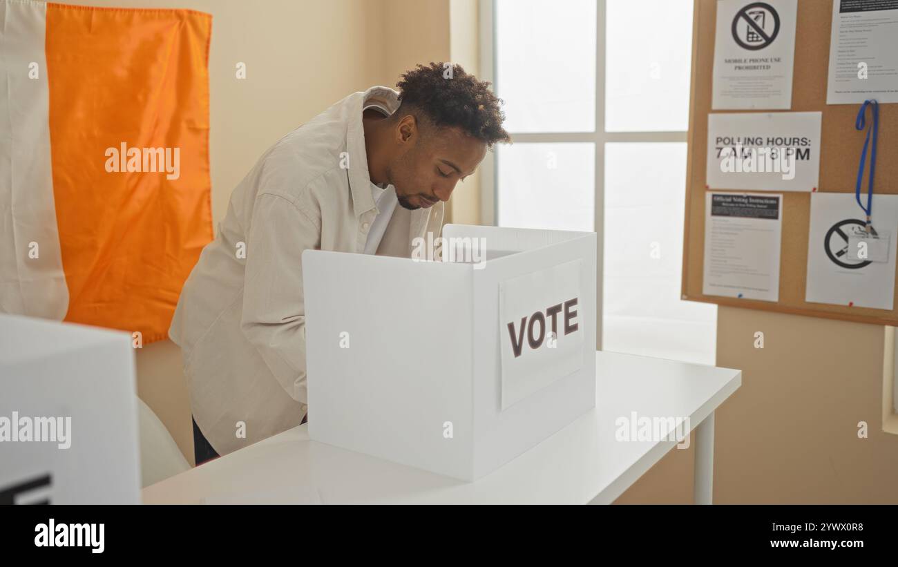 A young african american man voting indoors in an irish electoral ...