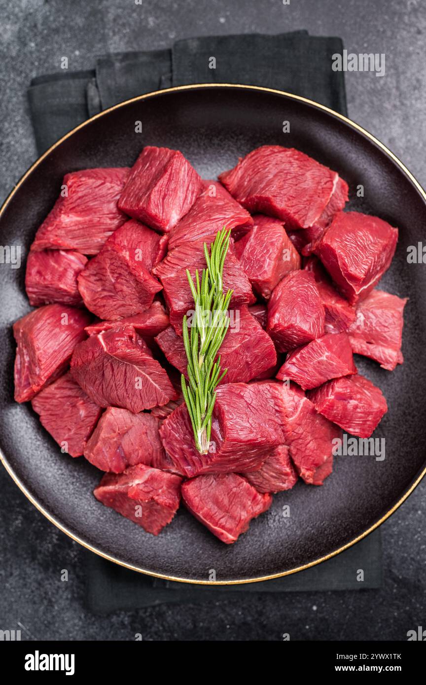 Diced Raw Boar meat, fresh Game Meat in a plate. black background. top ...