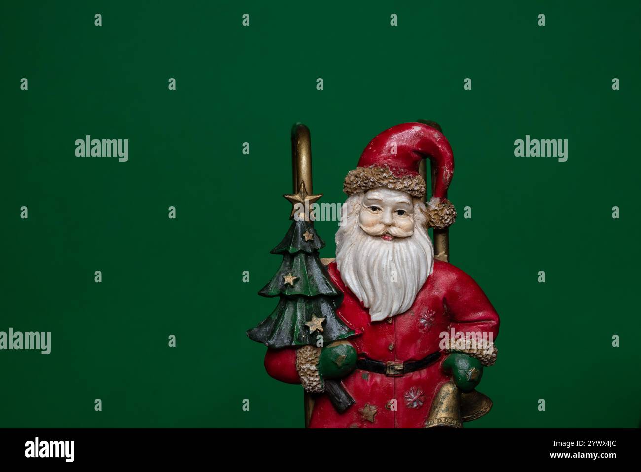 Santa Claus figure holding small christmas tree on green background ...