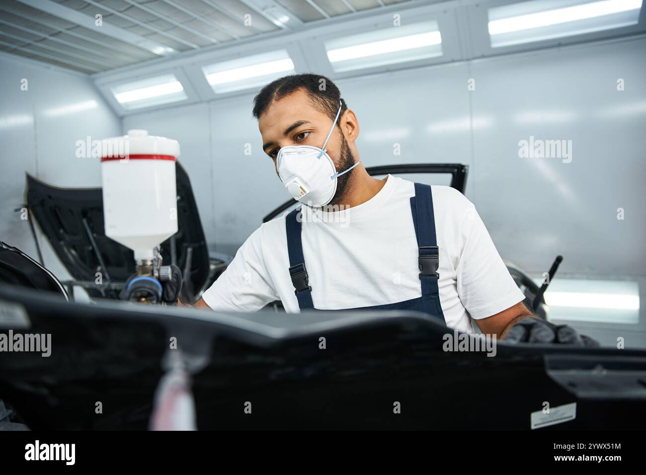 A skilled young mechanic focuses on his task while maintaining safety ...