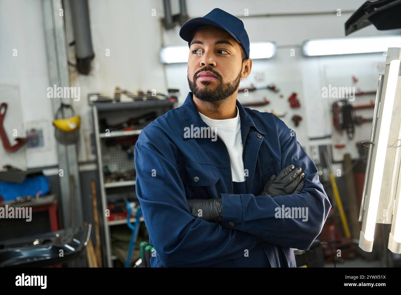 Smiling mechanic stands crossed arms hi-res stock photography and ...