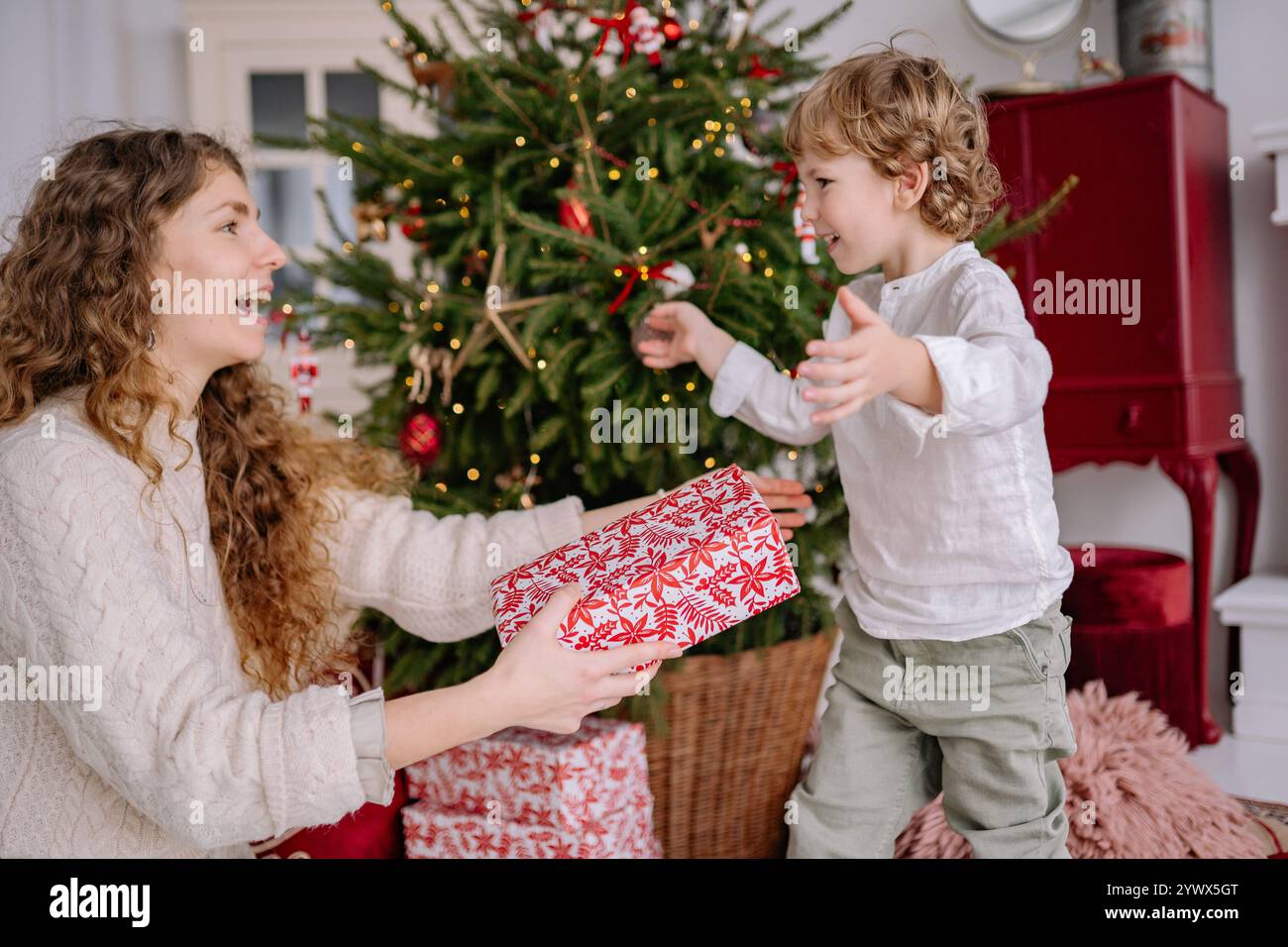 Child giving christmas present indoor hi-res stock photography and ...