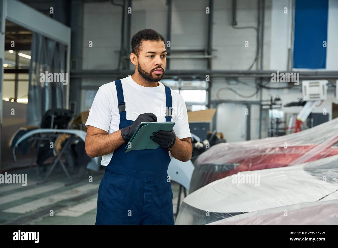 Skilled mechanic carefully examines vehicle components while taking ...