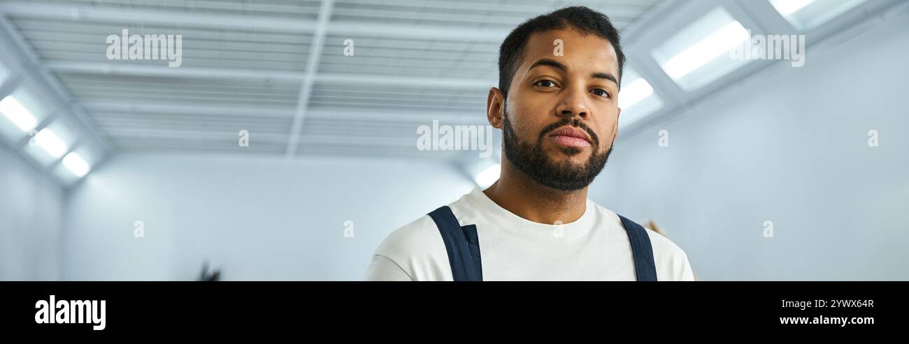 Skilled mechanic poses with pride in a well lit workshop filled with ...