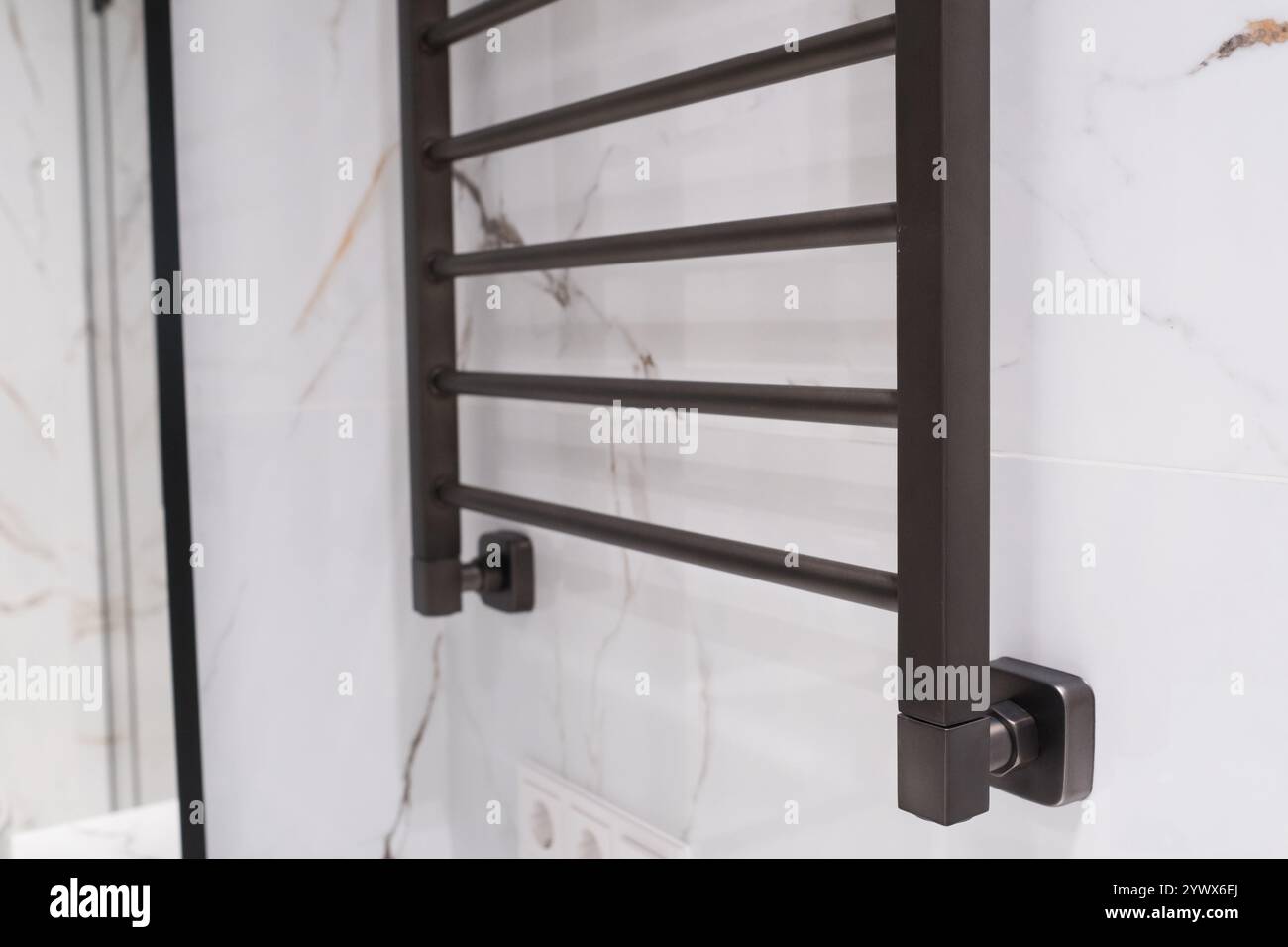 Modern black radiator on white marble wall in bathroom. New bathroom ...