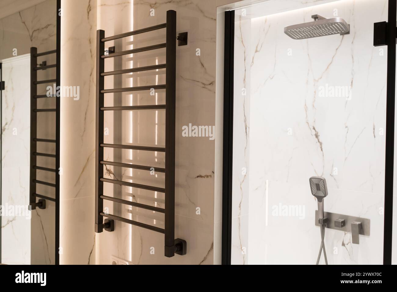 Modern black radiator on white marble wall in bathroom. New bathroom ...