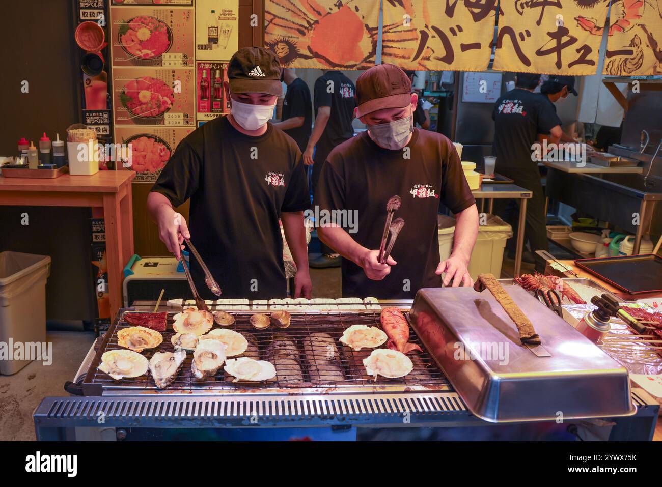 Men preparing seafood in a roadside restaurant in Outer Tsukiji Market ...