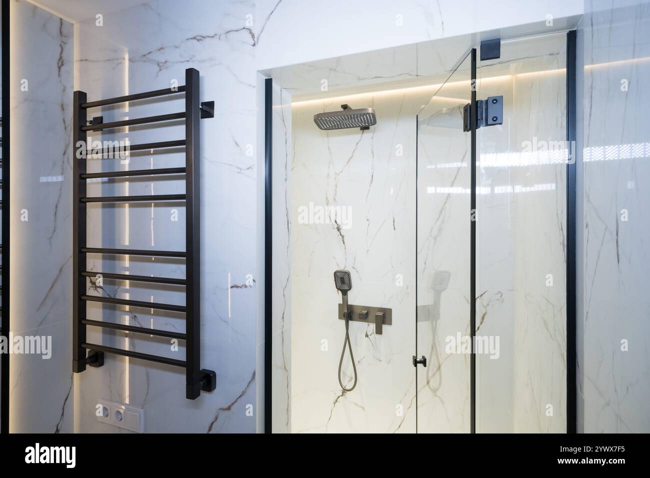 Modern black radiator on white marble wall in bathroom. New bathroom ...