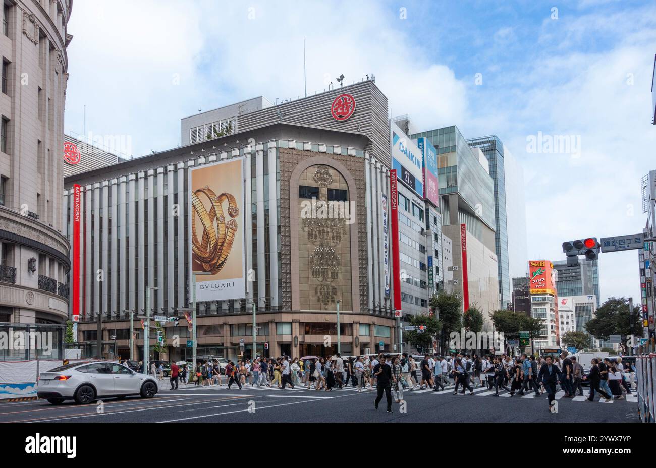 Pedestrians crossing the road in front of the Mitsukoshi Ginza department store building in ...