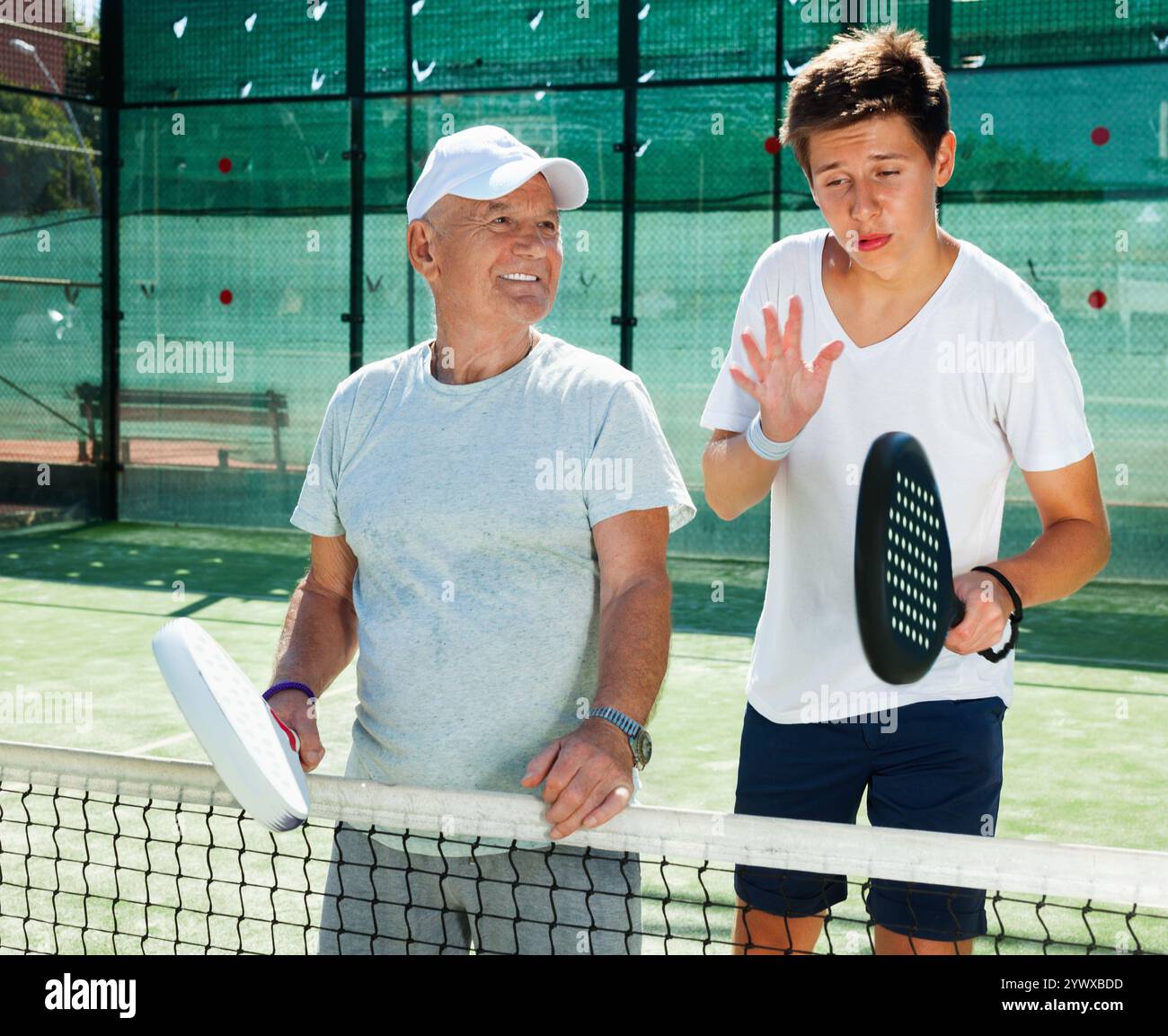 Padel players of different generations talking on court playing paddle ...