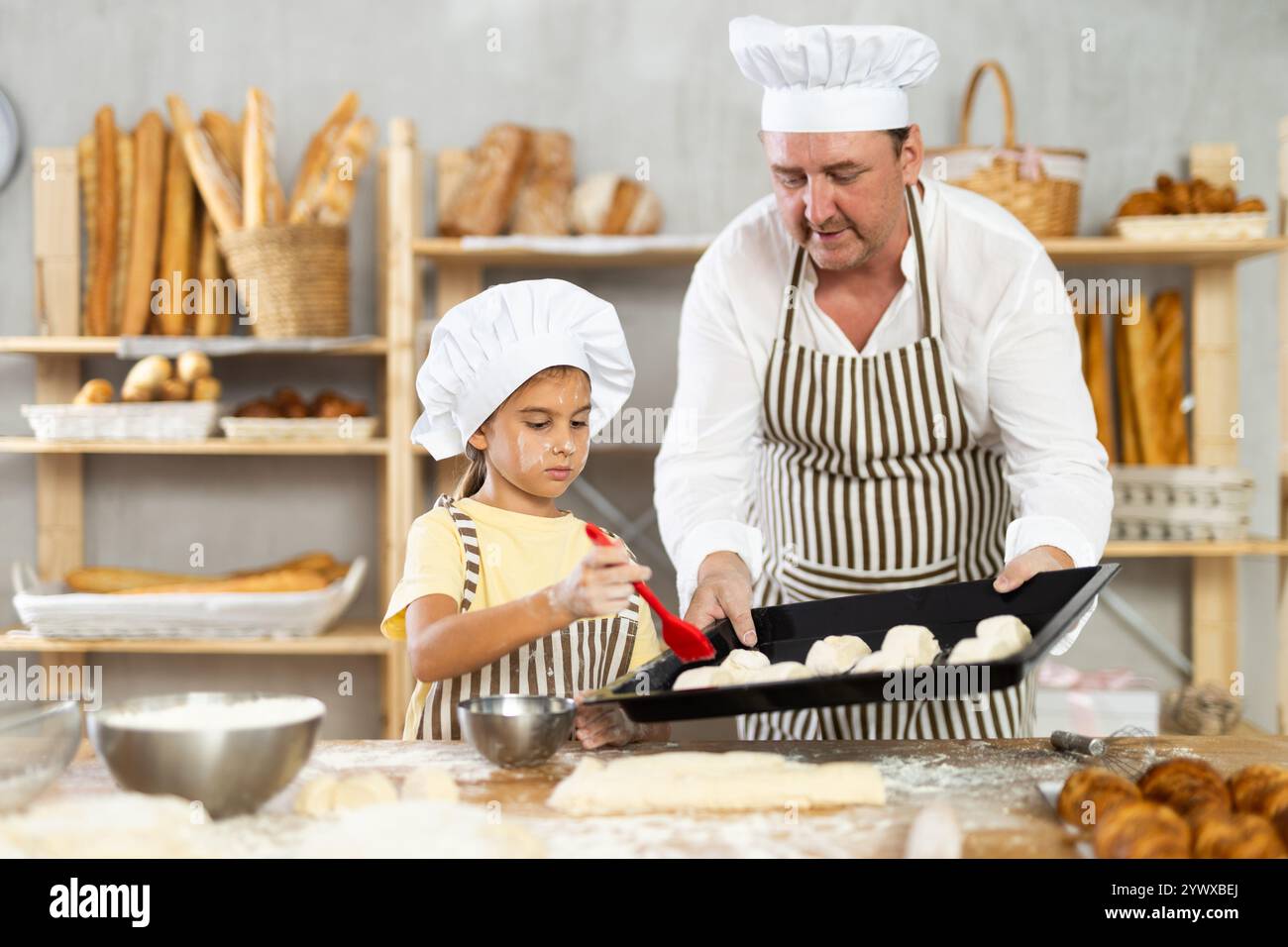 Daughter helps father baker to make pastries, lubricate croissants with ...