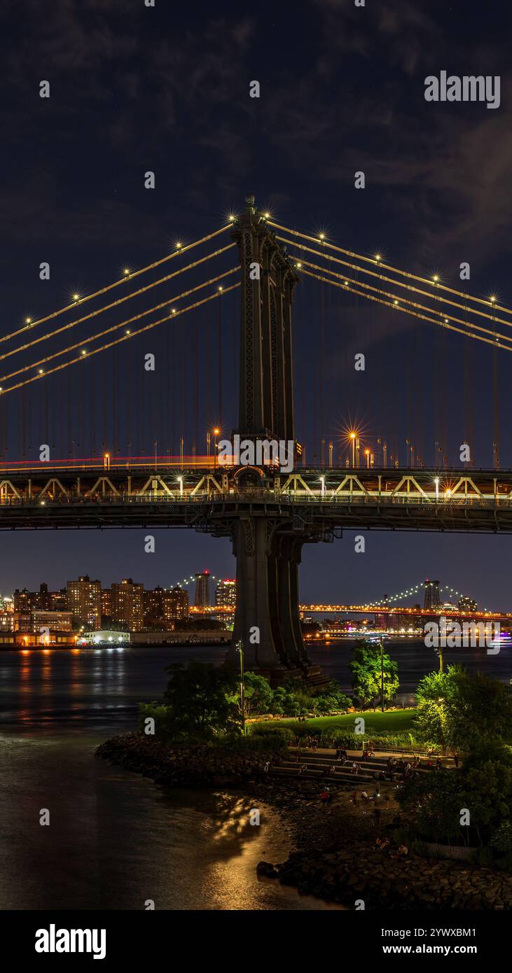 The photo captures the Manhattan Bridge at night from Brooklyn, with ...