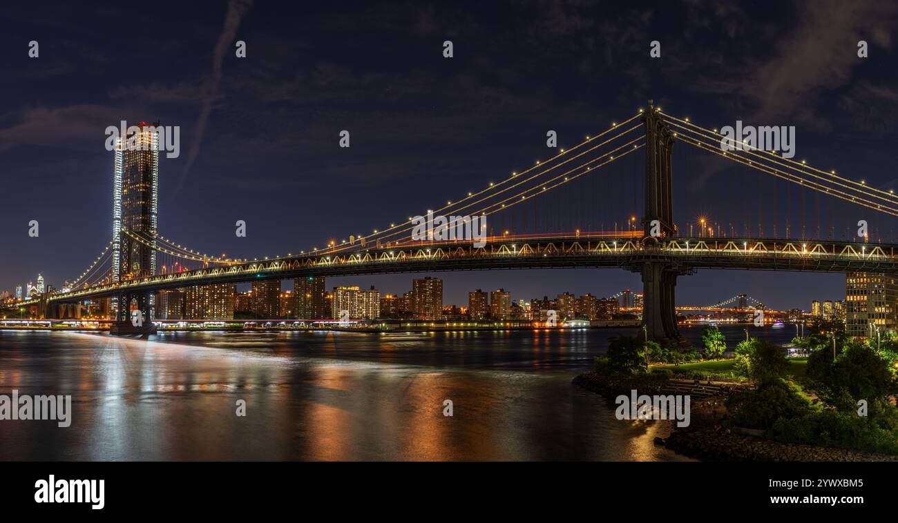 The photo captures the Manhattan Bridge at night from Brooklyn, with ...