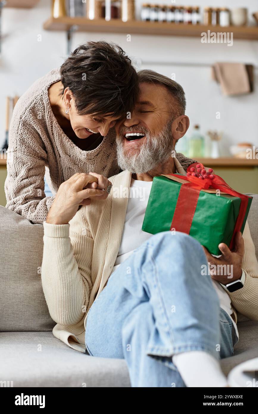 A couple shares a heartfelt moment exchanging a gift on a cozy day ...
