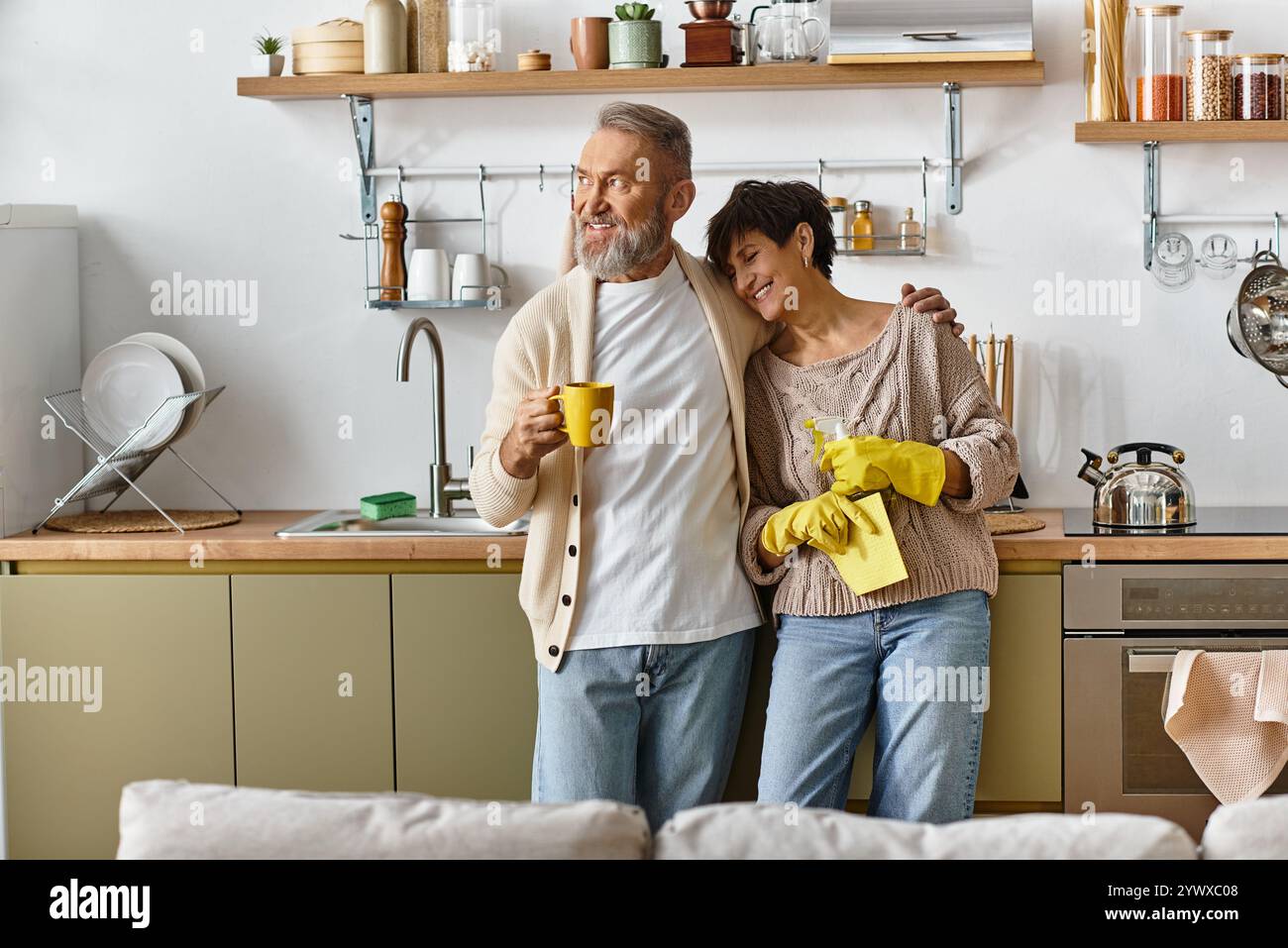 A loving couple shares a tender moment while tidying up their cheerful ...