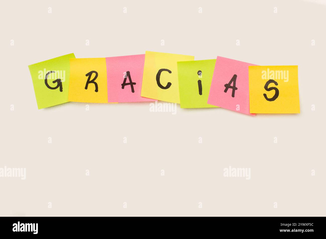 Gracias single word handwritten on colored sticky papers on a white ...