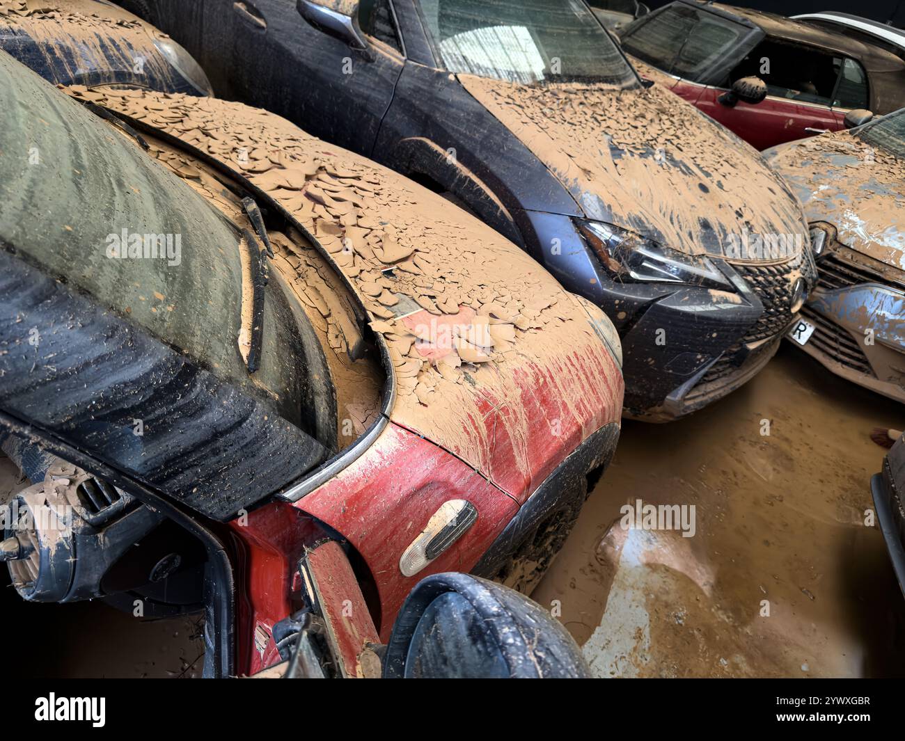 Numerous cars covered in mud and debris after severe flooding in Stock ...